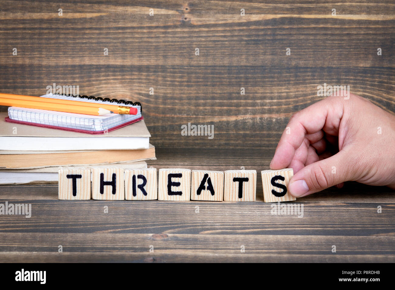 Threats. Wooden letters on the office desk, informative and ...