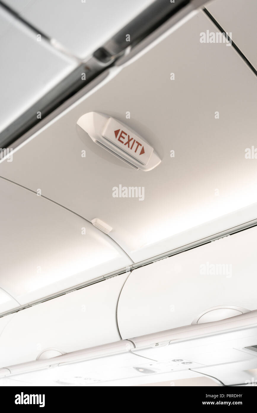 emergency exit sign on airplane. Empty airplane seats in the cabin ...