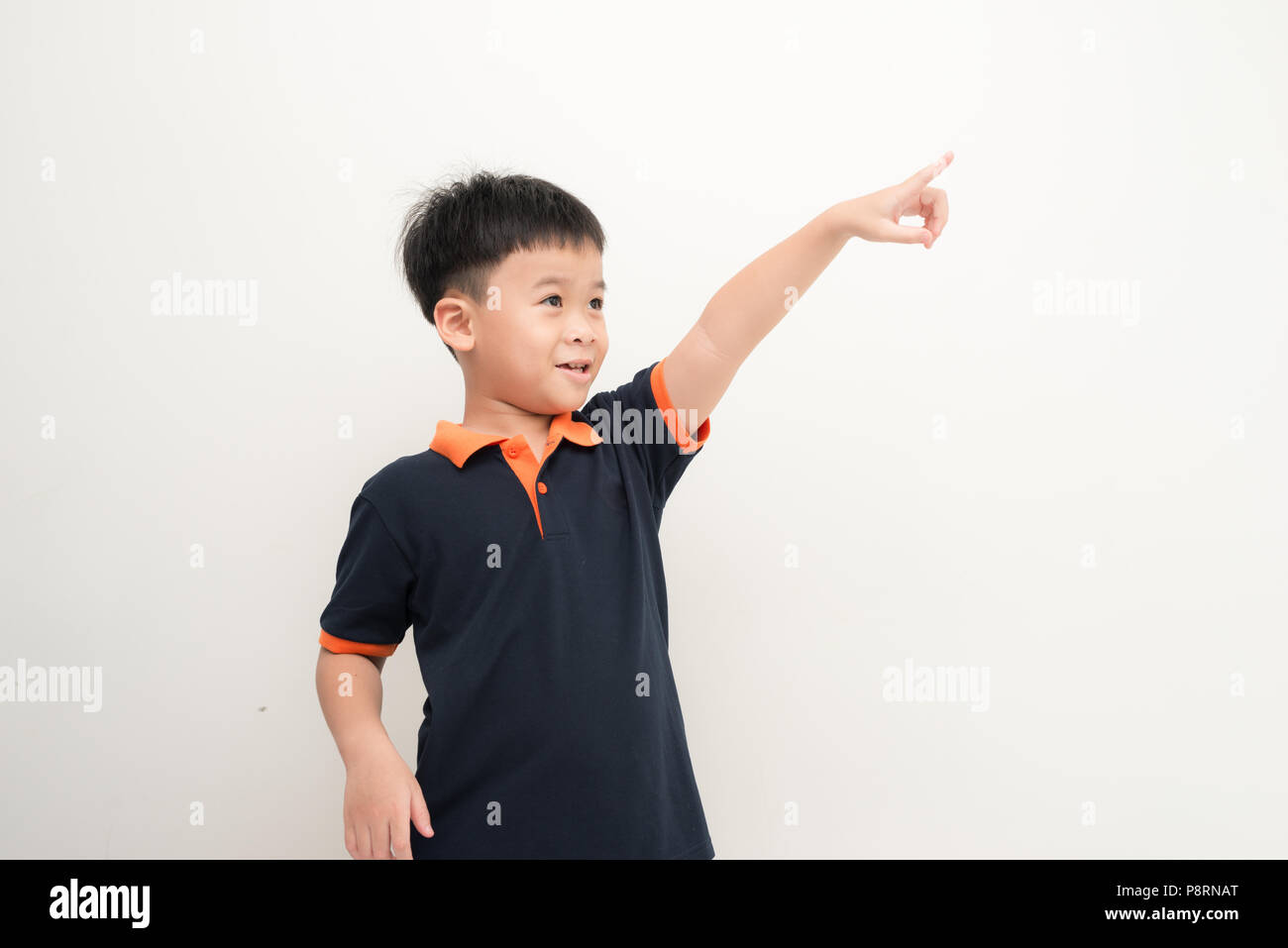 Close up portrait of cute boy pointing with finger into the distance ...