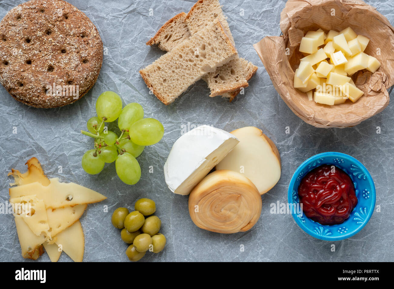 Cold appetizer. Cold cuts. Different snacks on a white crumpled paper ...
