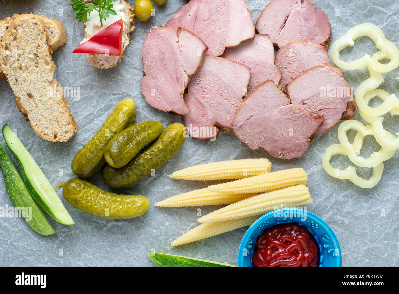 Cold appetizer. Cold cuts. Different snacks on a white crumpled paper ...