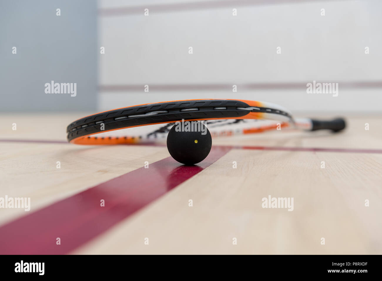 Squash racket and ball lying on the wooden floor of a court Stock Photo ...