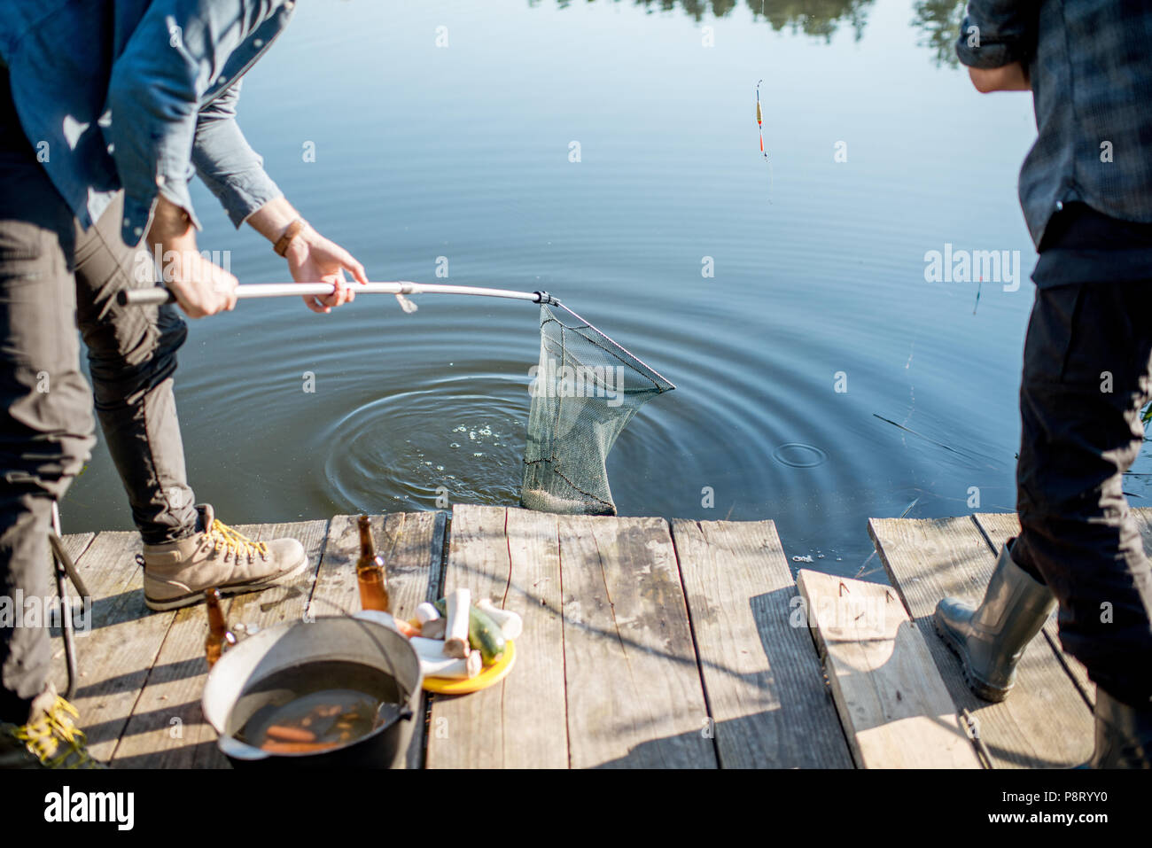 Man with big fish in net hi-res stock photography and images - Alamy