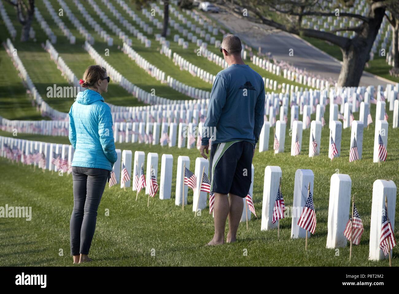 Visitors walking through rows of tombstones decorated with Star ...