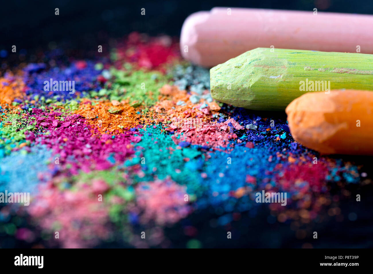 Crumbs of multi-colored chalk on a black background. A game for ...