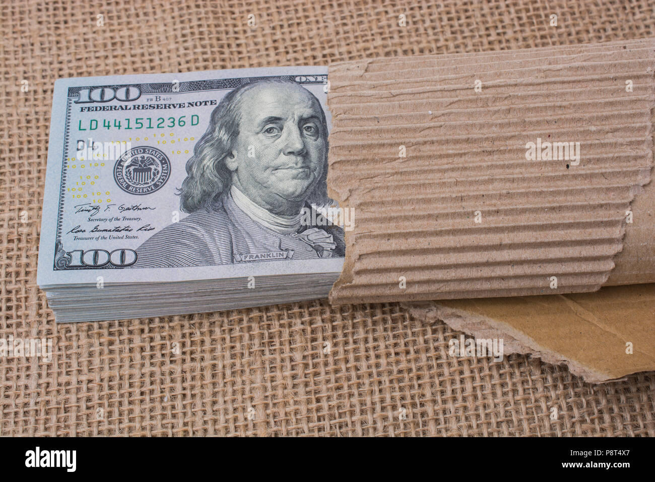 Banknote bundle of US dollar partly wrapped in cardboard Stock Photo ...
