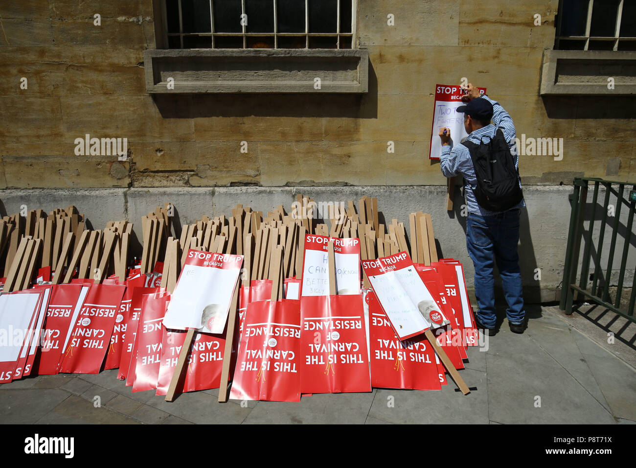 A protester writes a message on a placard near to Portland Place in ...