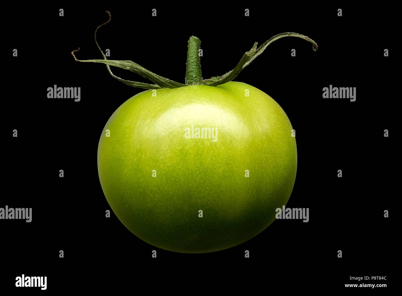 Delicious single green tomato isolated on black background with ...