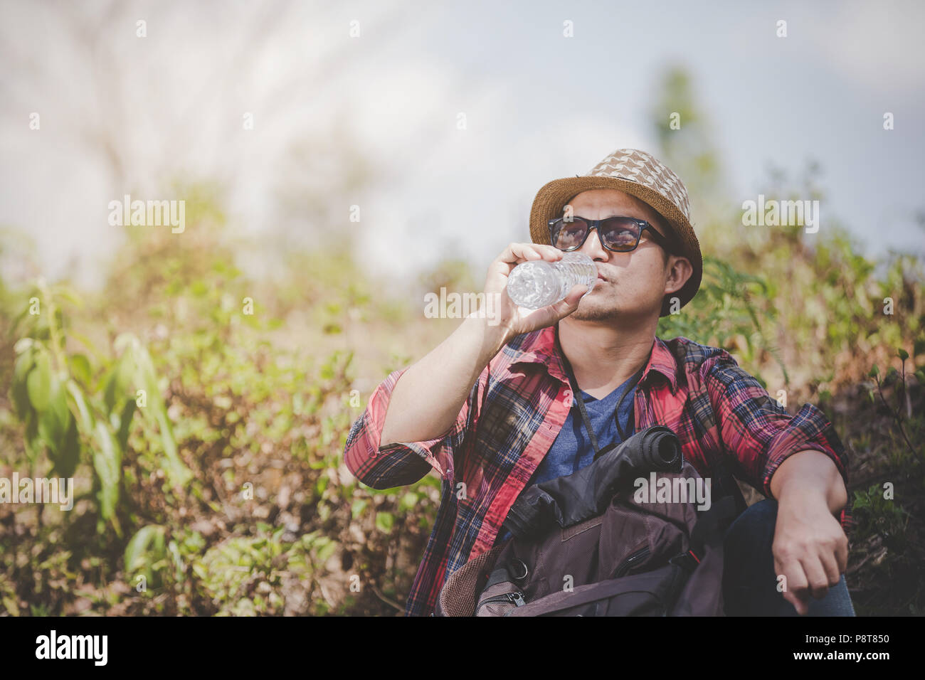 Asian male travelers to drink water on a green background, Hiking ...