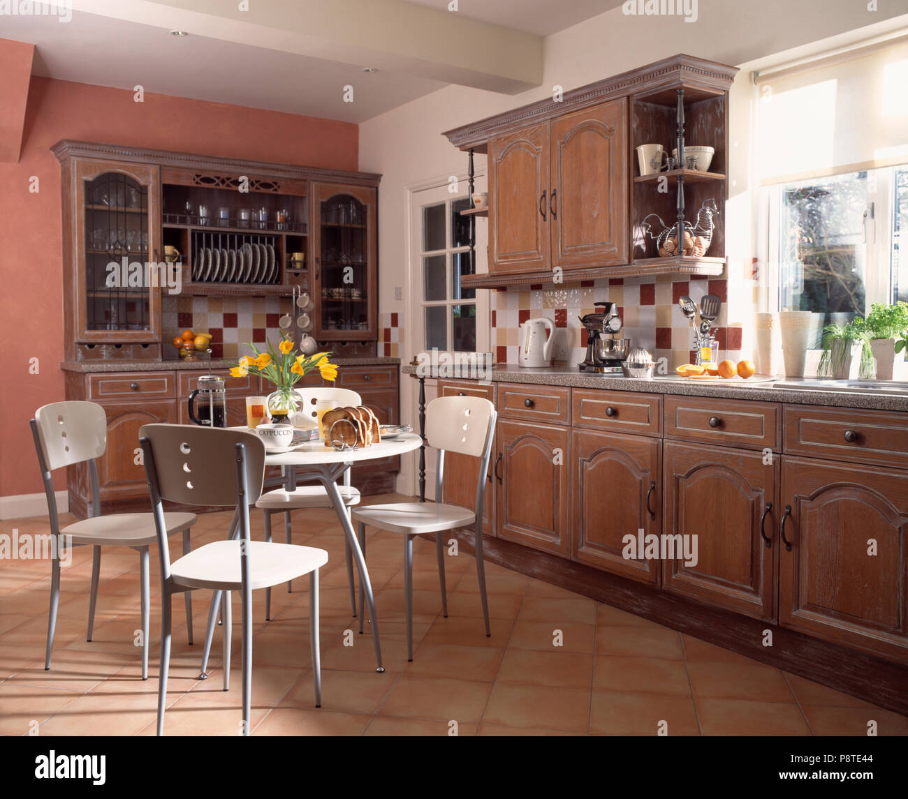 Modern table and chairs in traditional kitchen with fitted dresser and ...