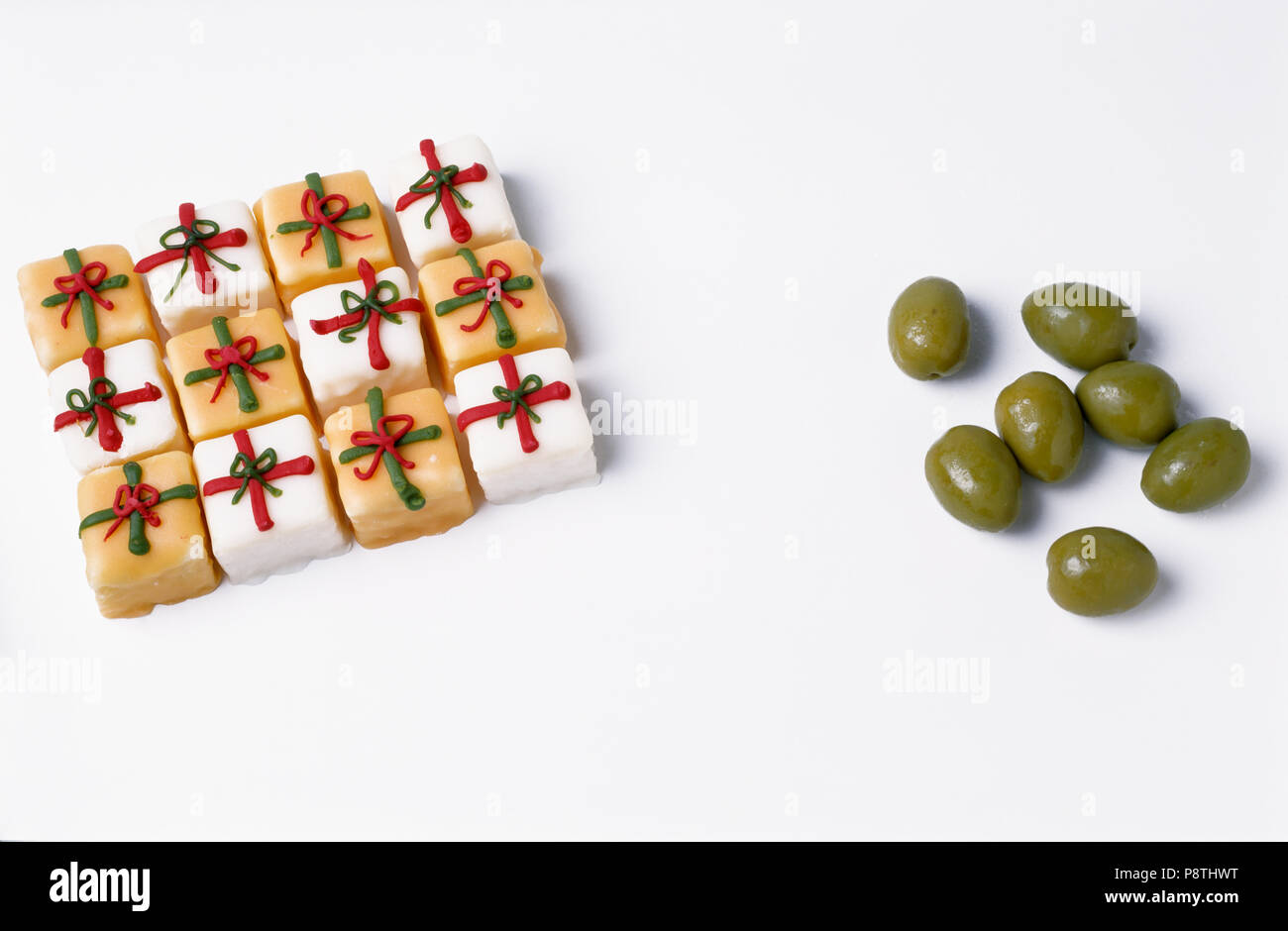 Close-up of small decoratively iced square cakes beside group of green ...