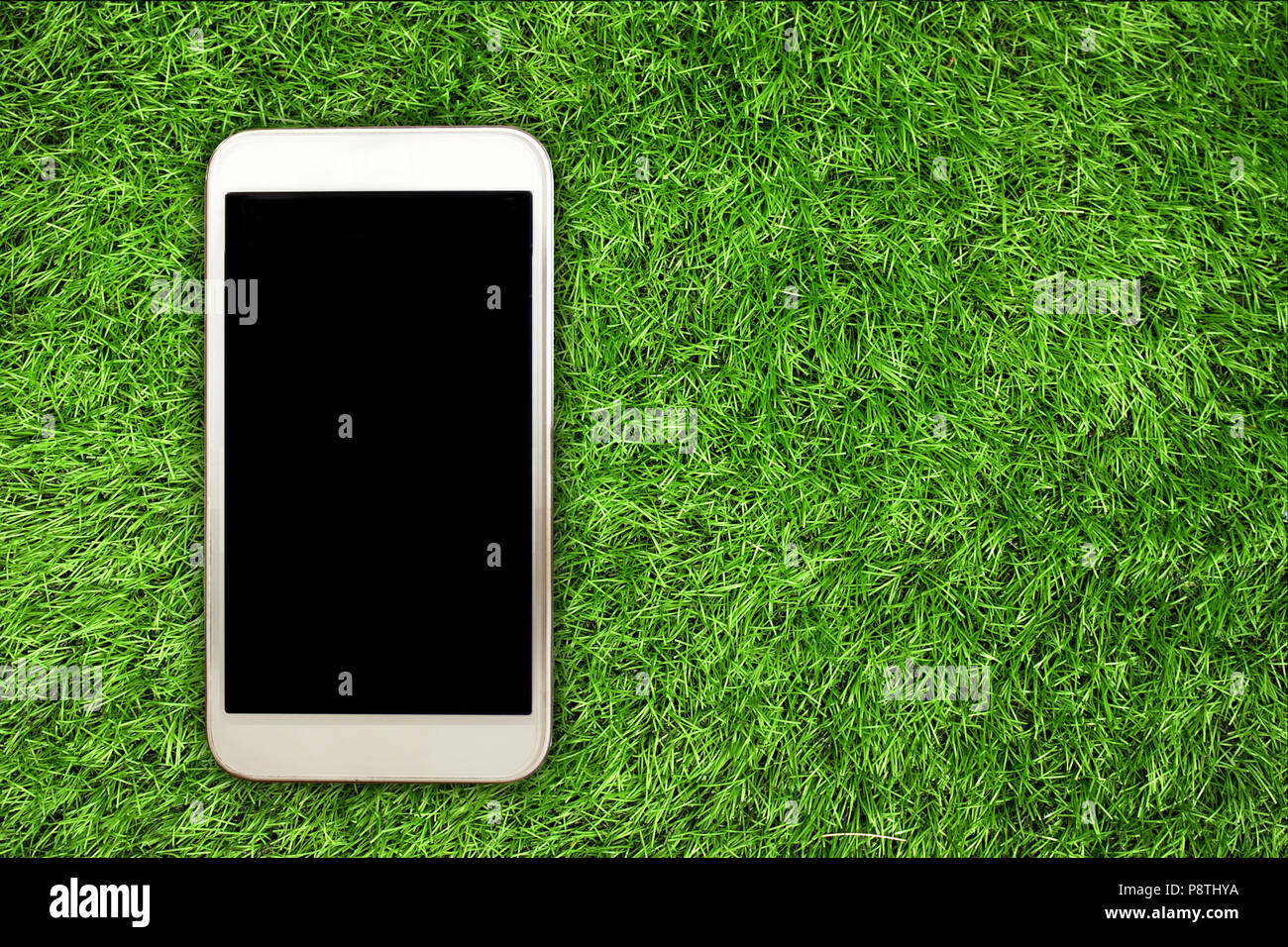 smartphone on grass background Stock Photo - Alamy