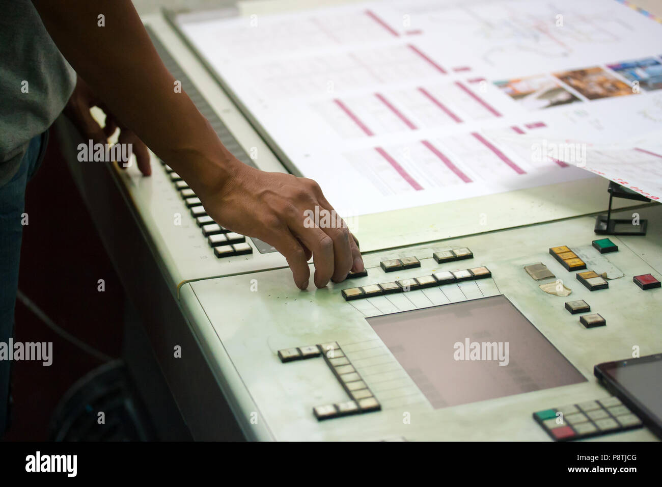 Printer checking a print run at table Stock Photo - Alamy