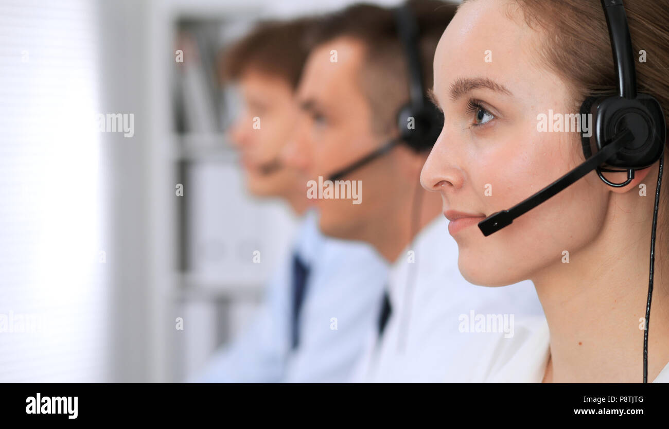 Call center. Focus on beautiful woman in headset Stock Photo - Alamy
