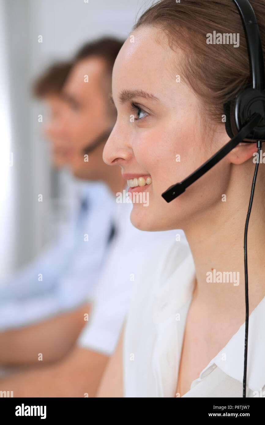 Call center. Focus on beautiful woman in headset Stock Photo - Alamy