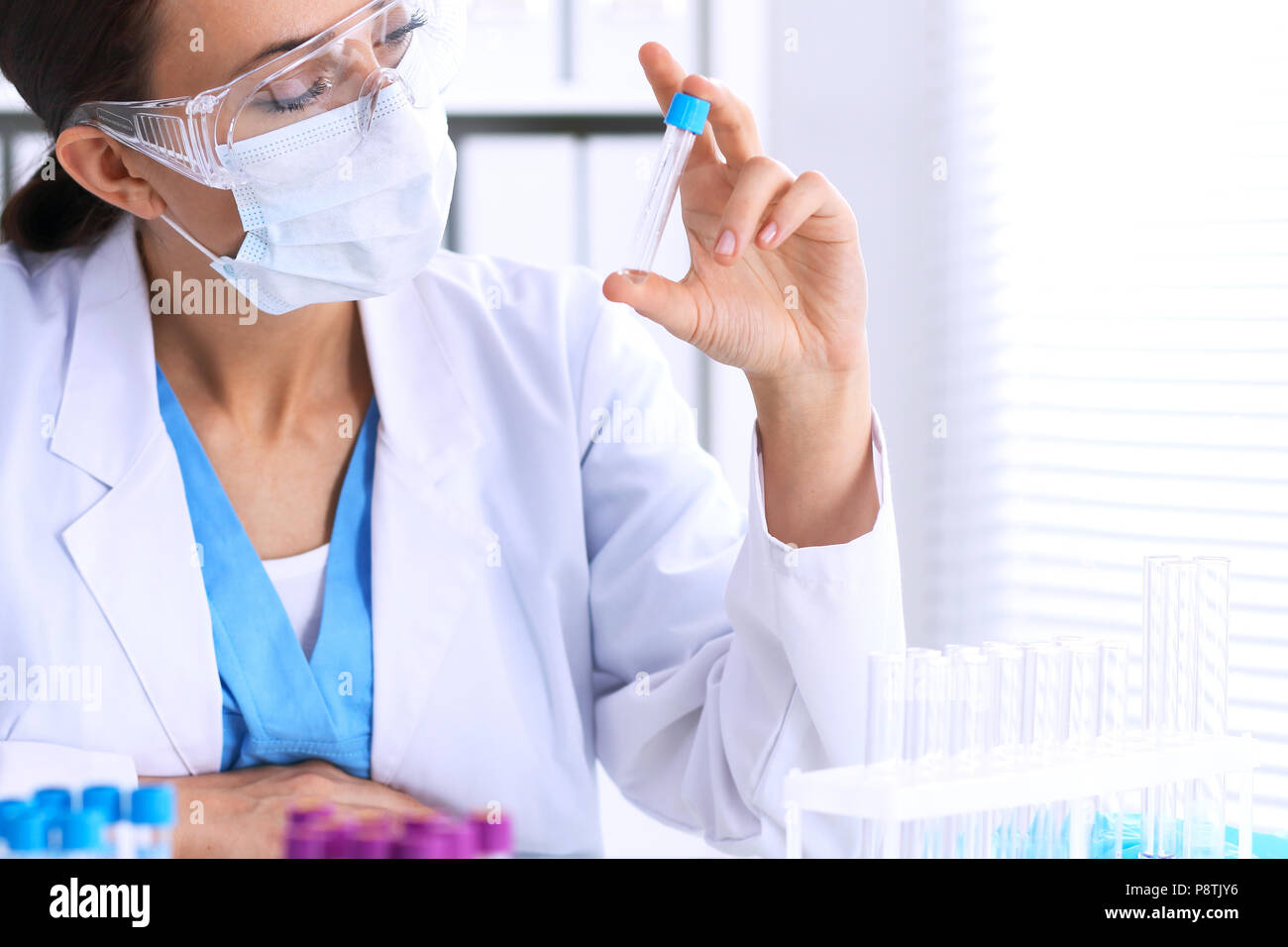 Female scientific research is looking at the tube in laboratory. Blood ...