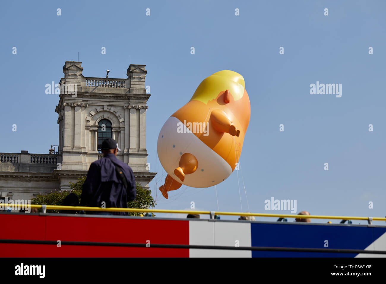 London, U.K. - 13 July 2018: A tourist on a bus passing a large balloon ...