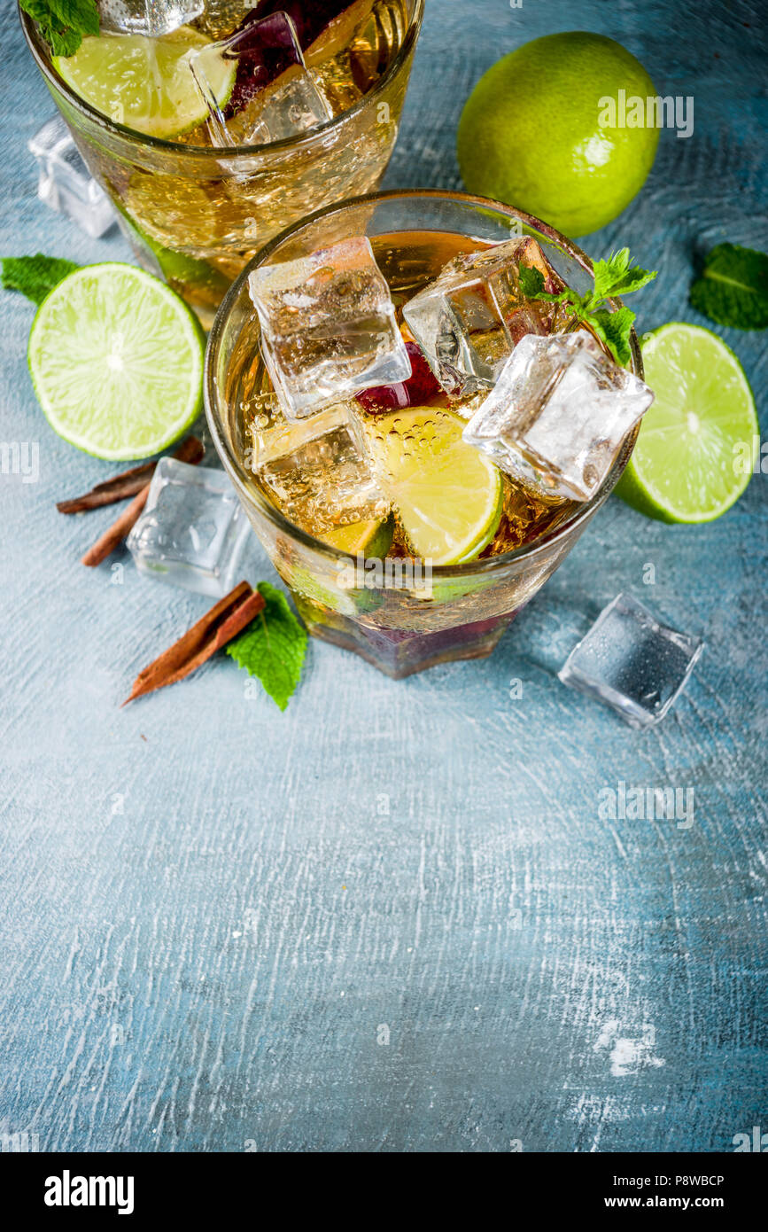 Summer iced tea with cinnamon, lime and mint leaves, copy space blue ...