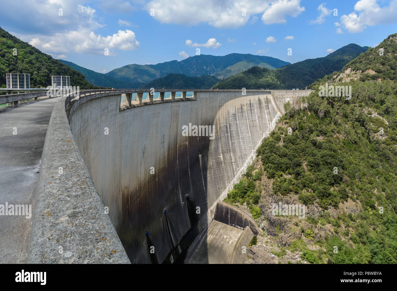 Rear side of a dam in front of trees taken in an angle to cover all its ...