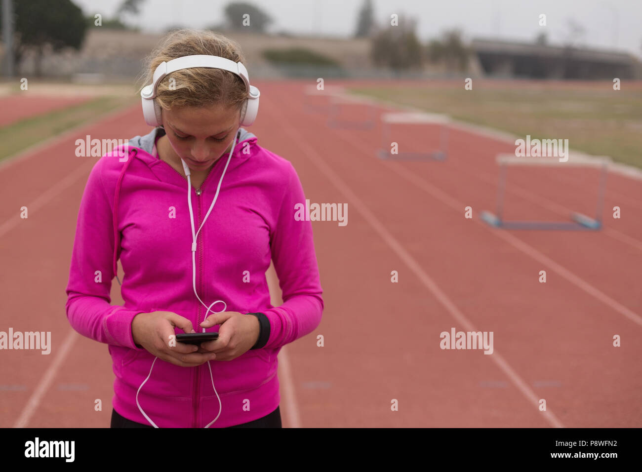 Female athlete listening music on mobile phone Stock Photo - Alamy