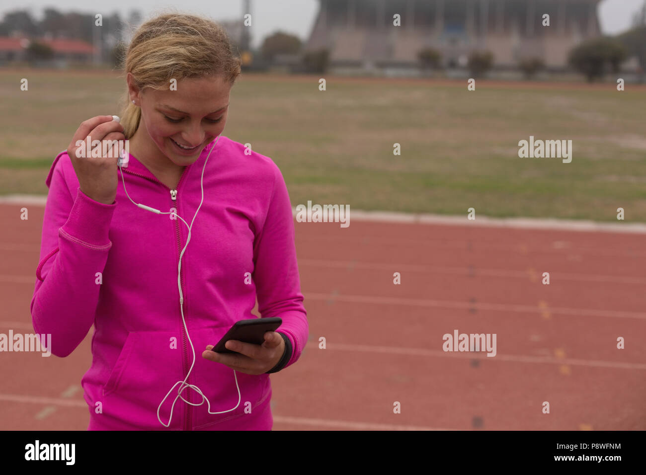 Female athlete listening music on mobile phone Stock Photo - Alamy