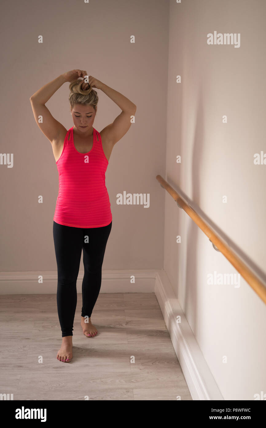 Woman standing with hands on hair Stock Photo - Alamy