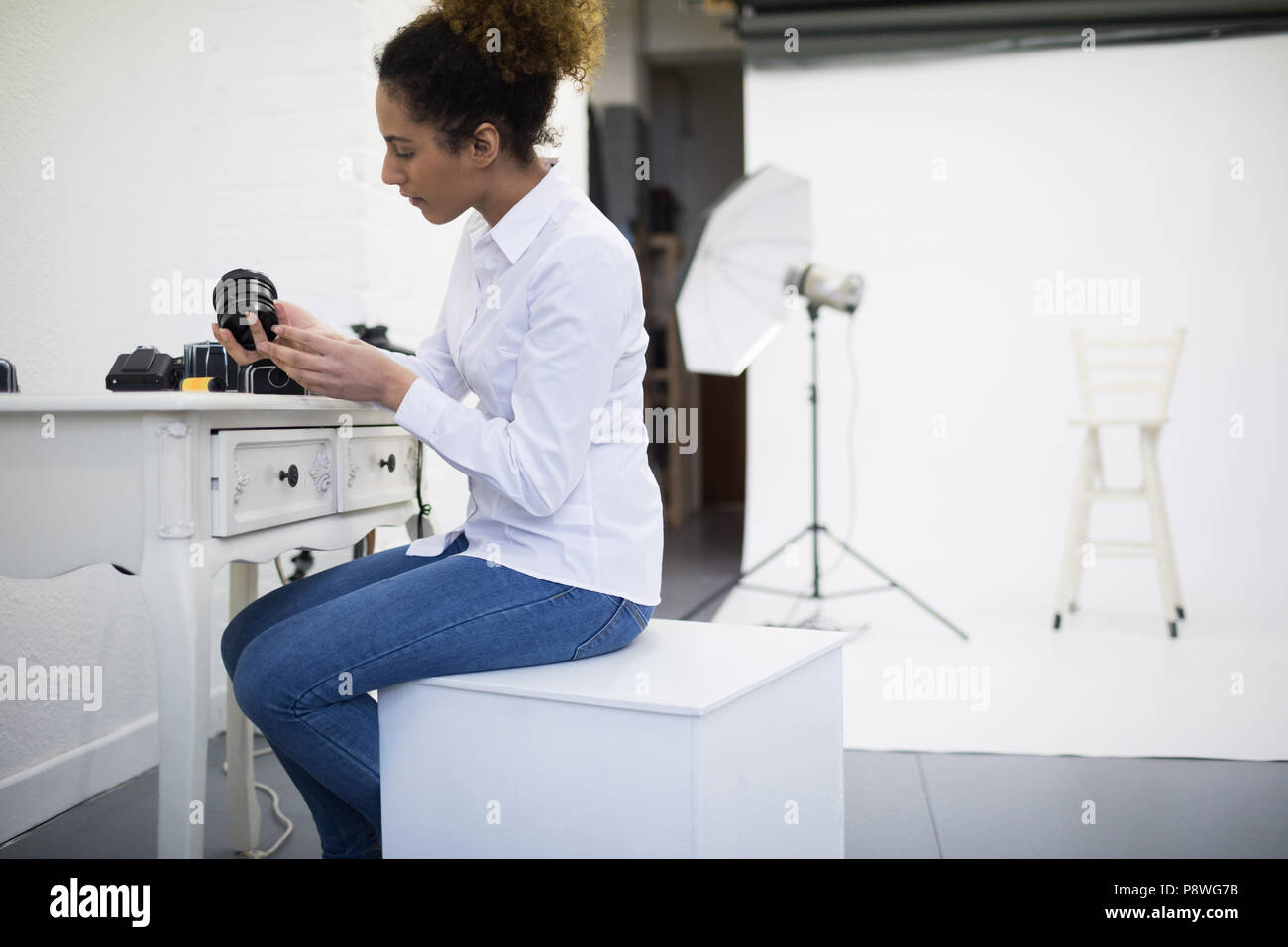 Female photographer checking camera lens Stock Photo - Alamy