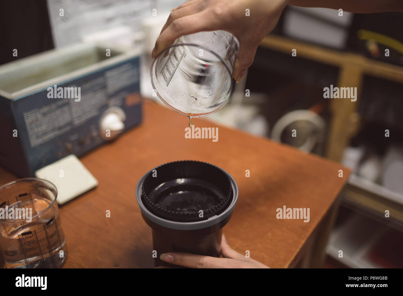Female photographer pouring a chemical on lens cover Stock Photo - Alamy