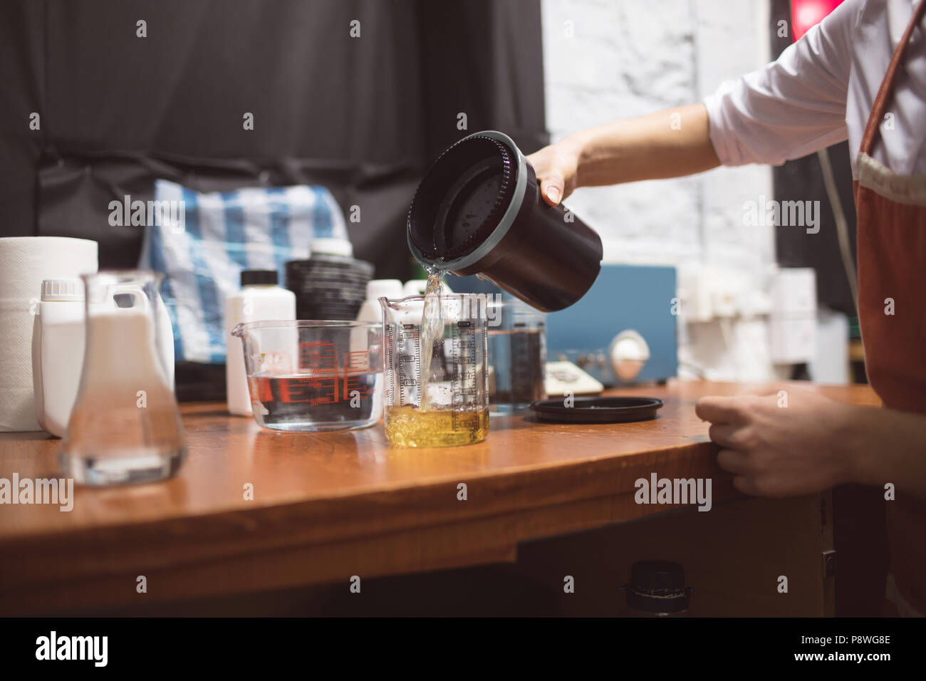 Female photographer pouring a chemical in flask Stock Photo - Alamy