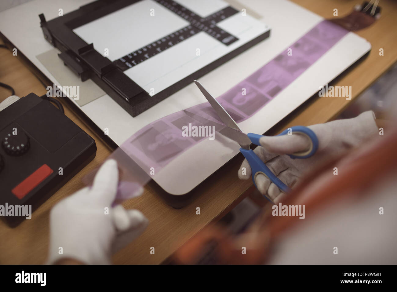 Female photographer cutting filmstrip with photos Stock Photo - Alamy