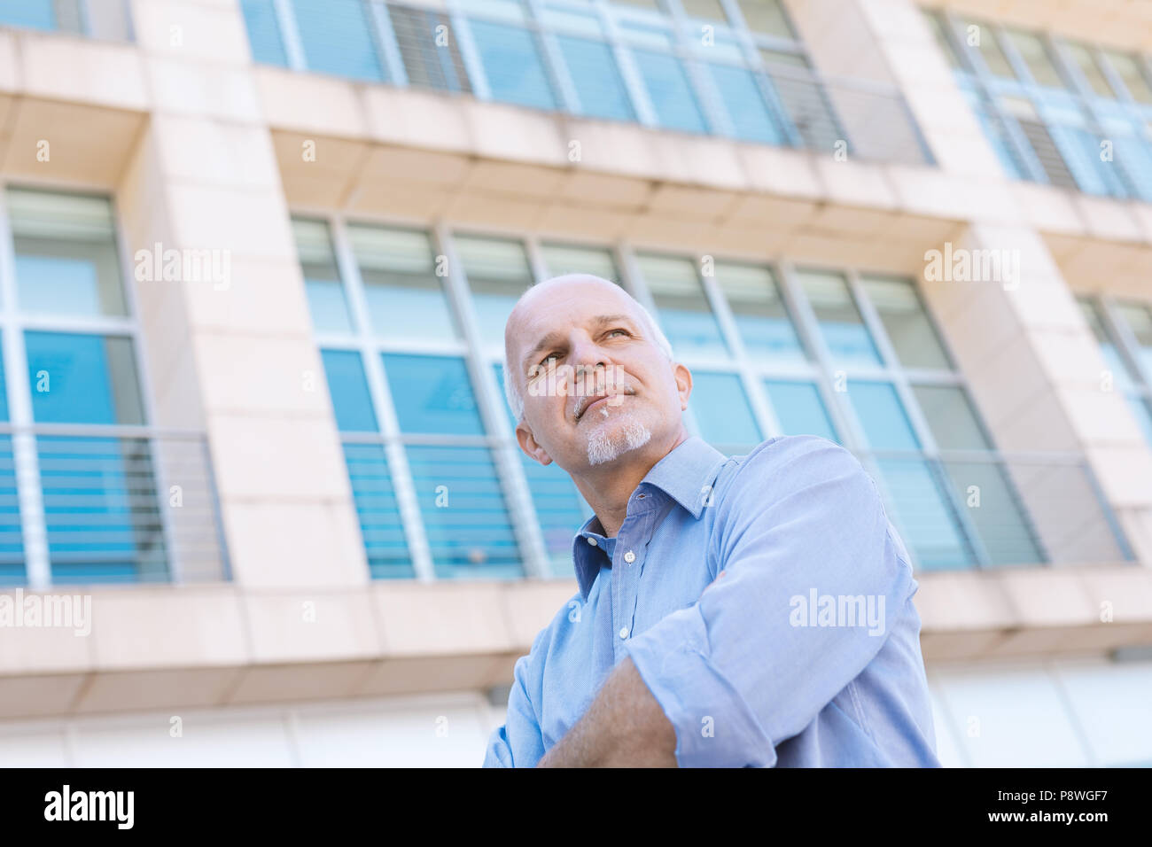Low angle view of Business man looking off in the distance with ...