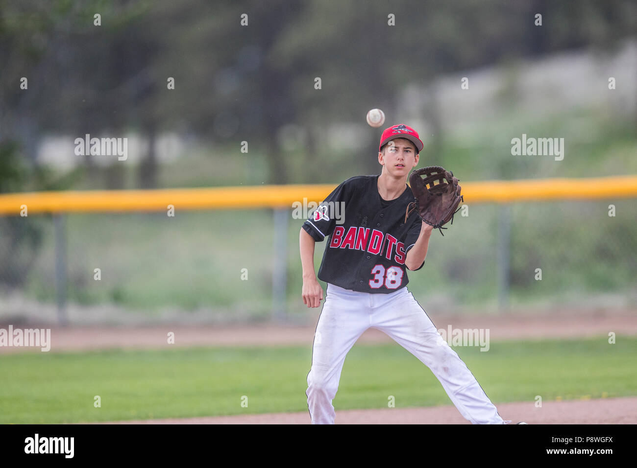 Ball just before hitting glove of infielder, boys afternoon junior ...