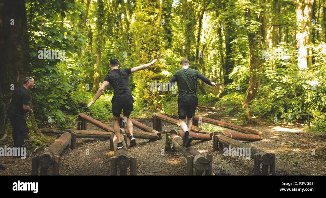 Fit mens training over obstacle course Stock Photo - Alamy