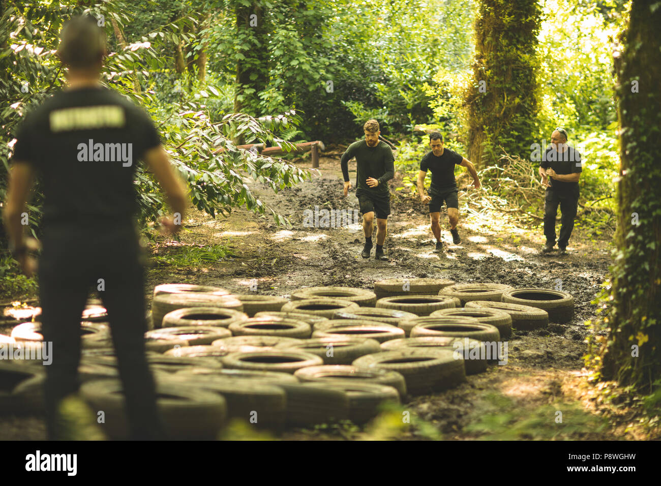 Fit mens training over tyres obstacle course Stock Photo - Alamy