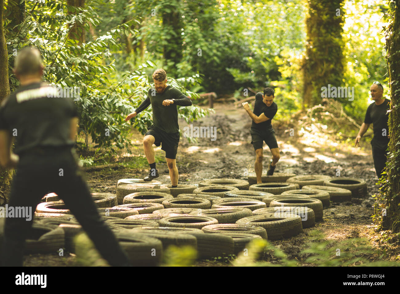 Fit mens training over tyres obstacle course Stock Photo - Alamy