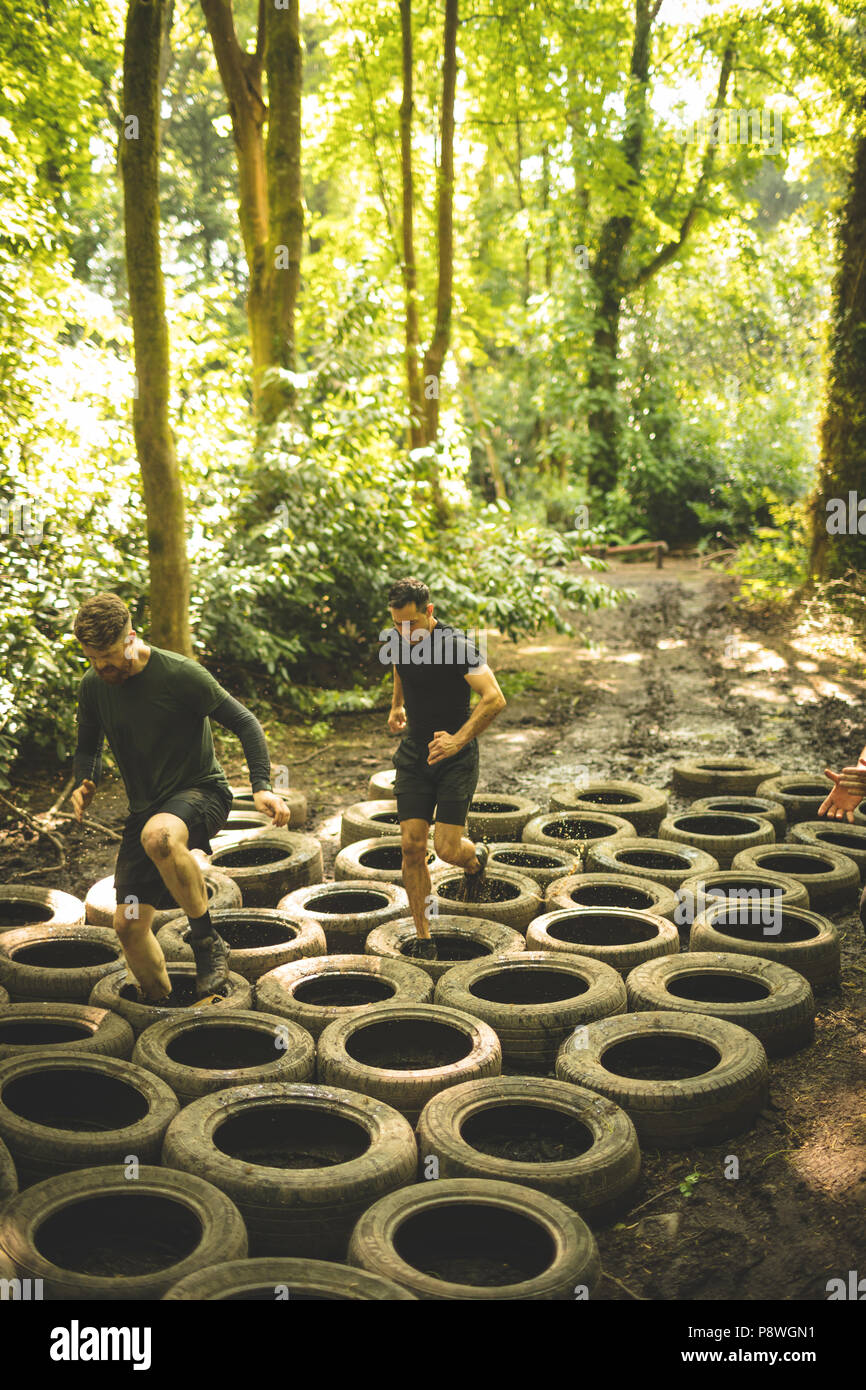 Fit mens training over tyres obstacle course Stock Photo - Alamy