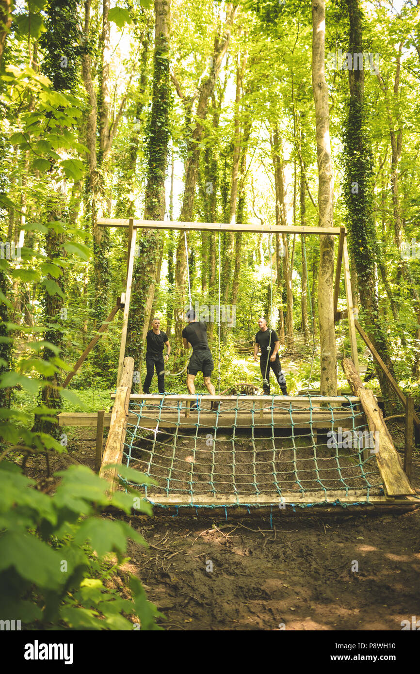 Fit mens training over obstacle course Stock Photo - Alamy