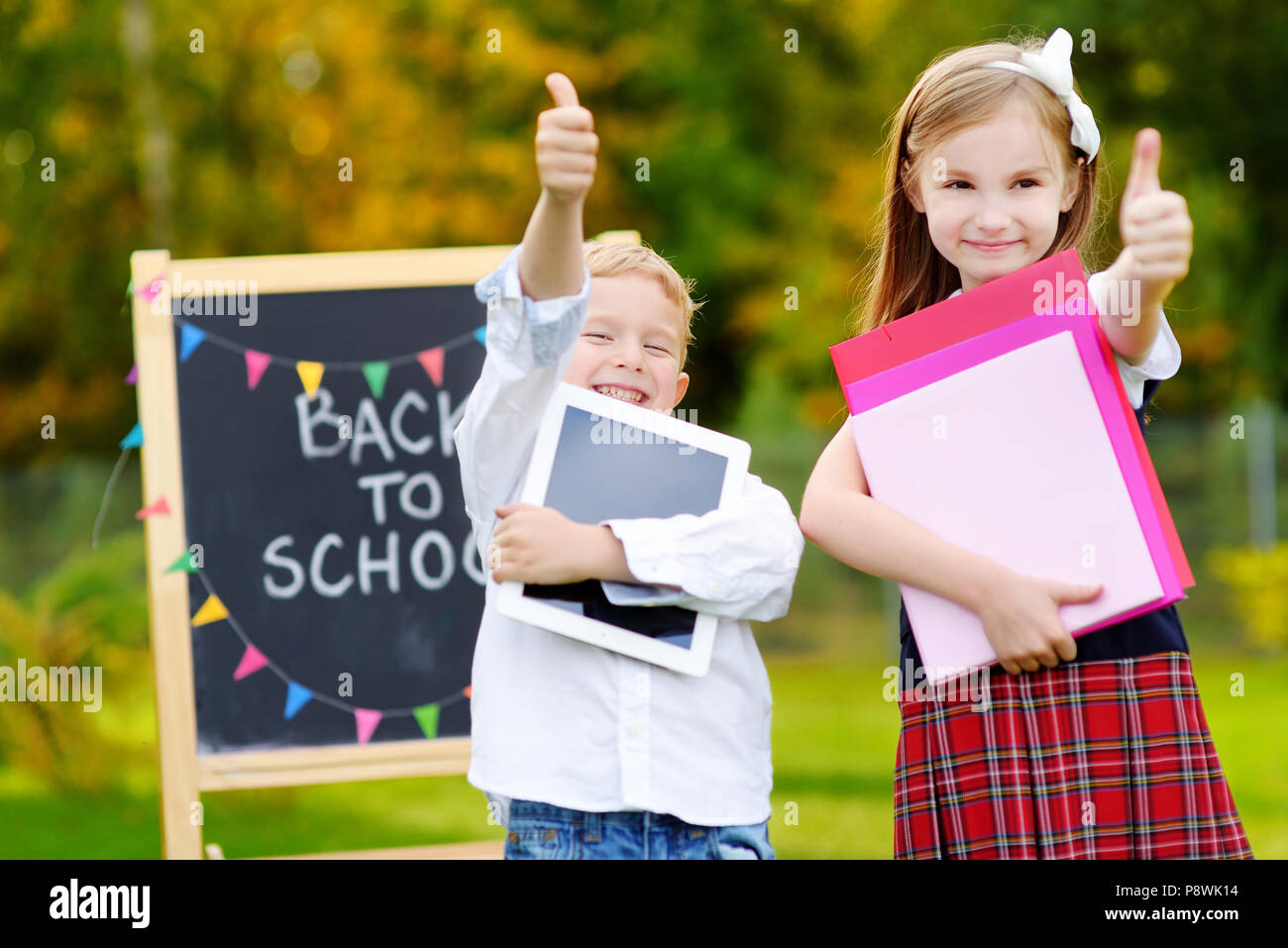 Two adorable little schoolkids feeling very exited about going back to ...