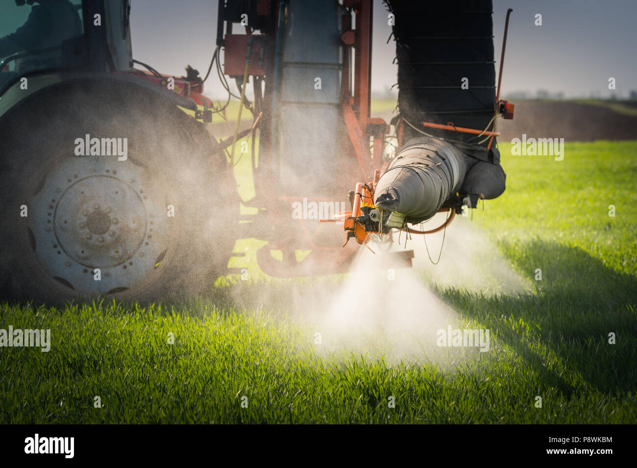 Tractor spraying wheat field with sprayer Stock Photo - Alamy