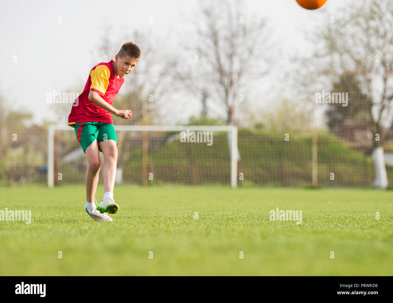 kid kicking a soccer ball on the field Stock Photo - Alamy