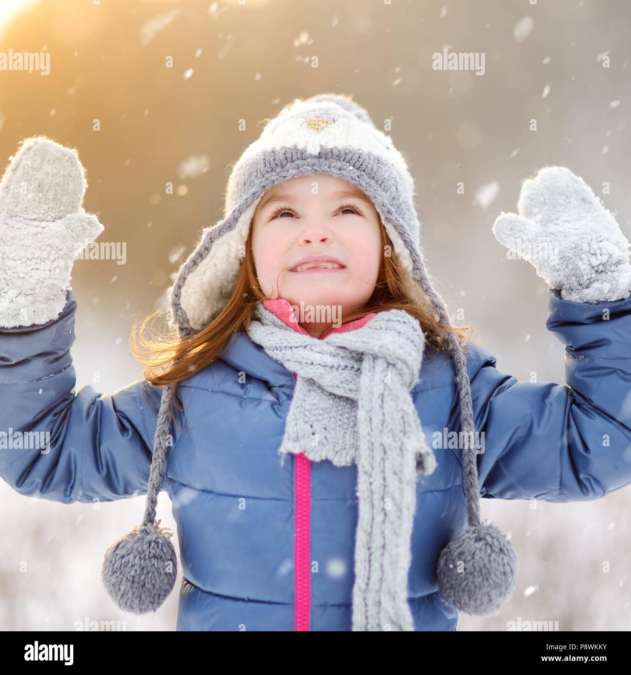 Funny little girl catching snowflakes with her tongue in beautiful ...