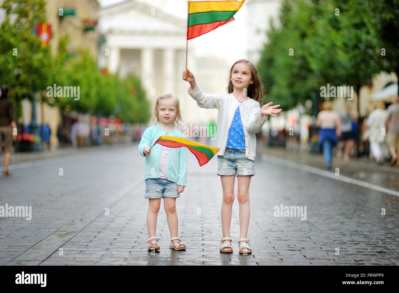 Two adorable little sisters holding Lithuanian flags in Vilnius, the ...