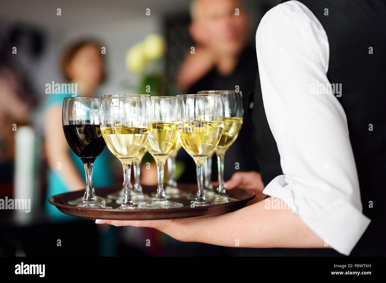 Waitress holding a dish of champagne and wine glasses at some festive ...
