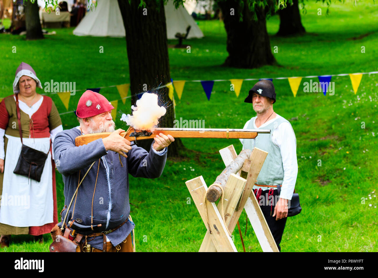 Man in medieval costume, firing harquebus, arquebus, early ...