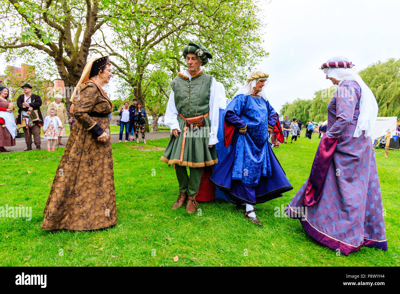 Medieval dancing outdoors. Living history group of people dressed in ...