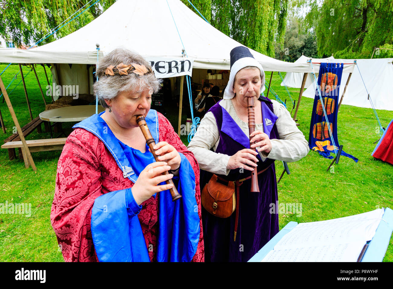 Two women wearing outfits of medieval traveling minstrel, entertainer ...