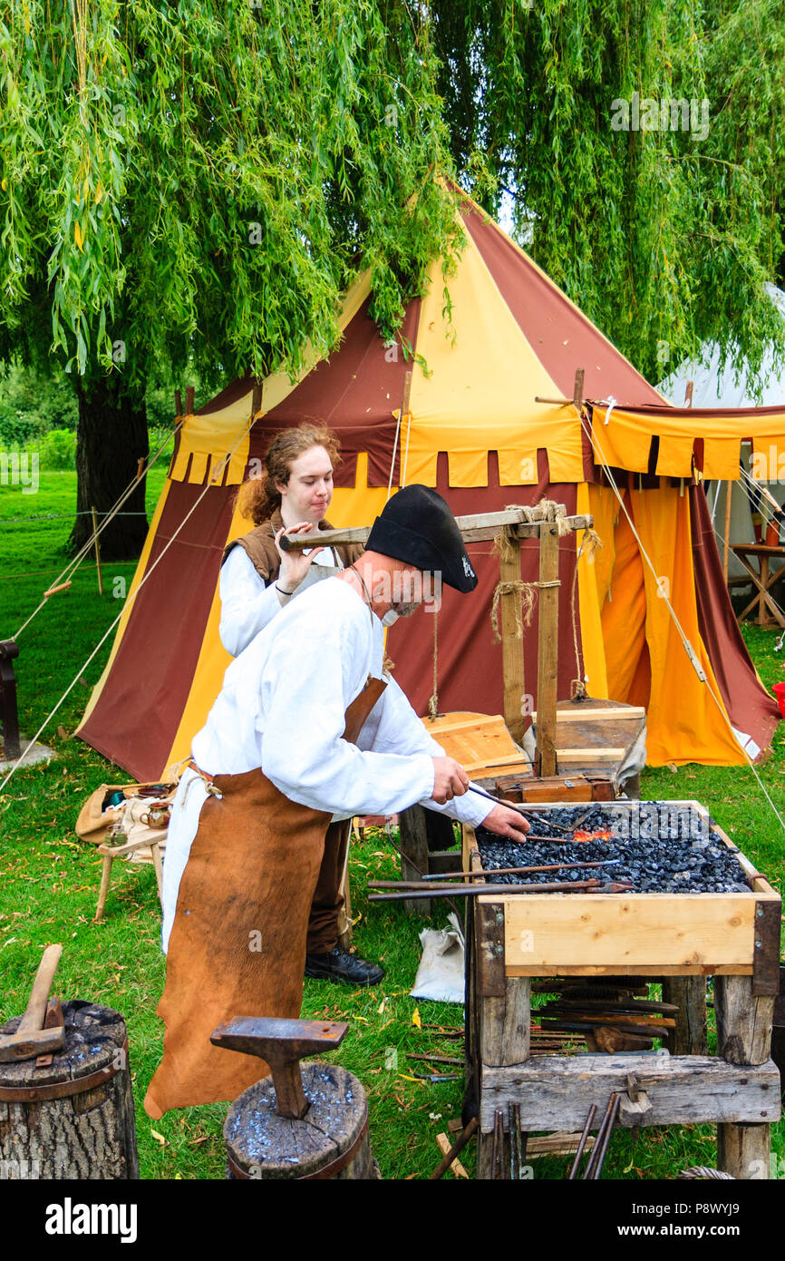 Living history, outdoor re-enactment event. Medieval man, blacksmith ...