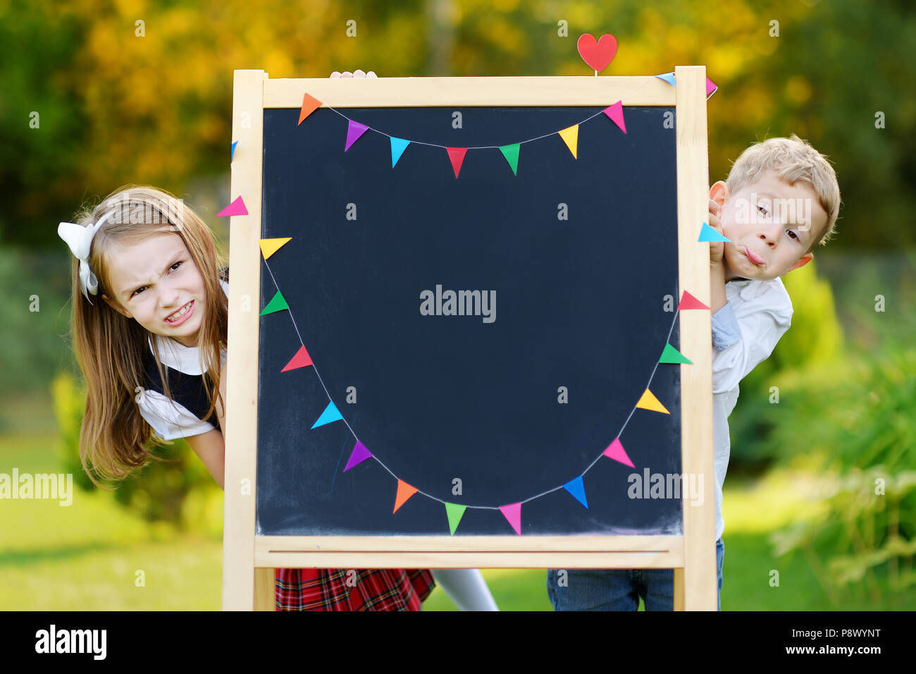 Two adorable little schoolkids feeling very exited about going back to ...
