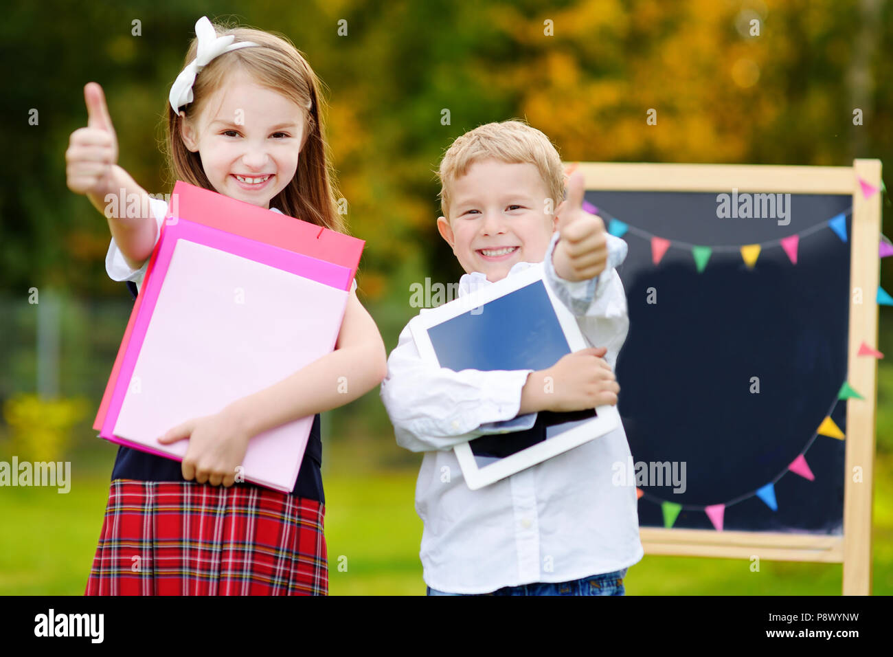 Two adorable little schoolkids feeling very exited about going back to ...
