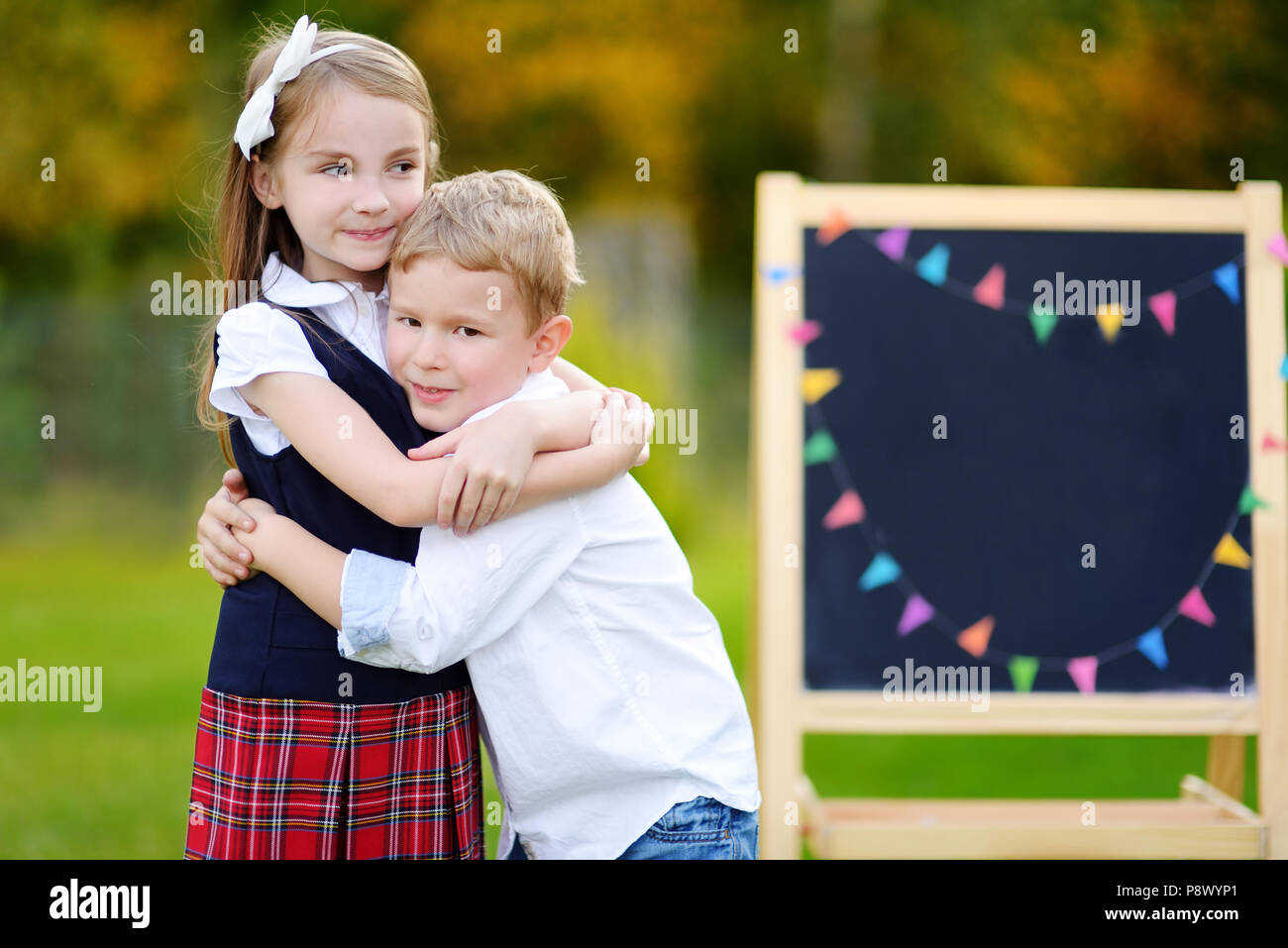 Two adorable little schoolkids feeling very exited about going back to ...